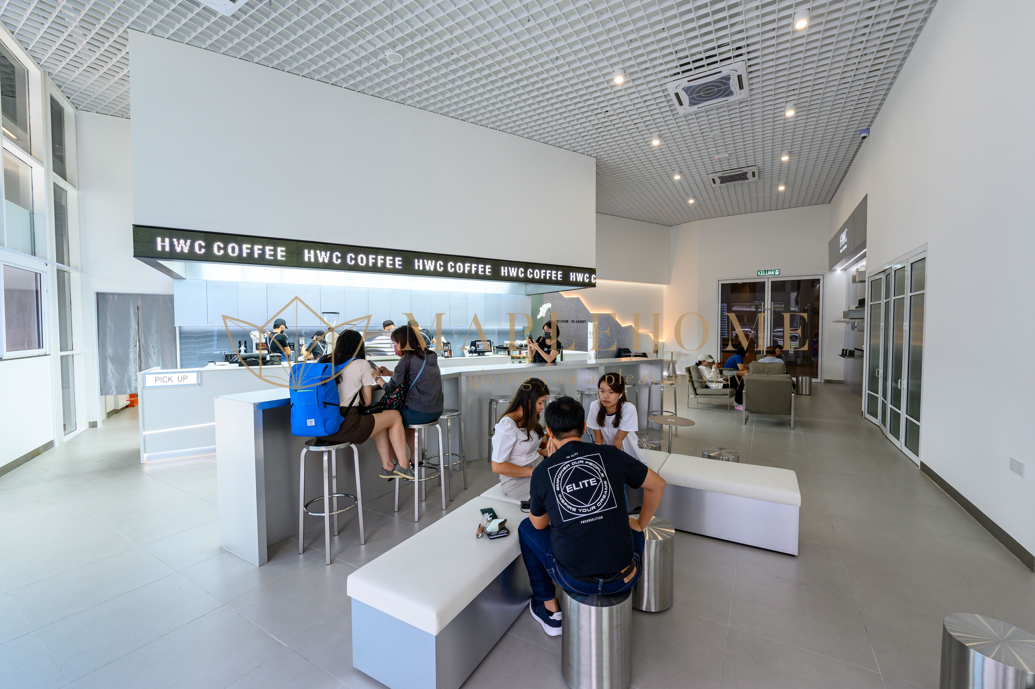 Uma área moderna de café com assentos e um aviso 'PICK UP'.