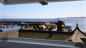 Vista de um porto com barcos, um cais e edifícios.