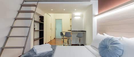 Quarto com uma cama de beliche, uma escrivaninha e duas cadeiras.