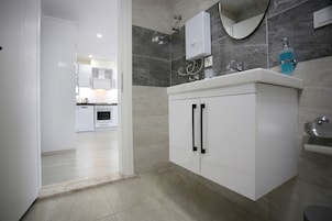Apartamento Standard, 1 quarto | Casa de banho | Um polibã, um chuveiro fixo, um secador de cabelo, chinelos