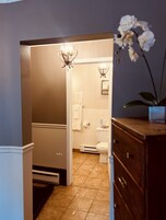 Uma casa de banho com sanita, lavatório e porta-toalhas.