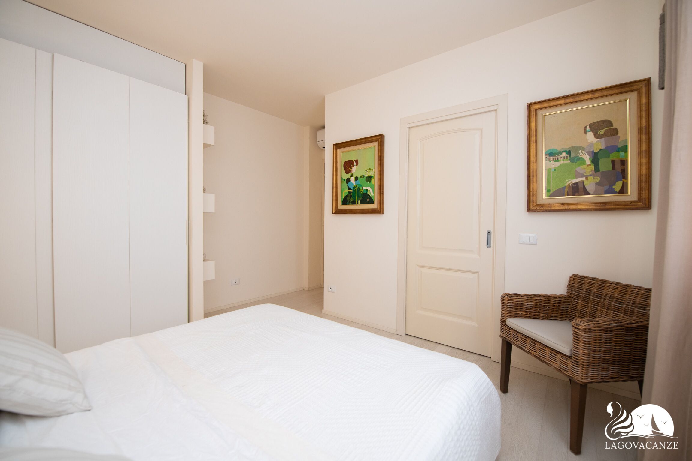 Quarto com uma cama, uma cadeira e duas portas.