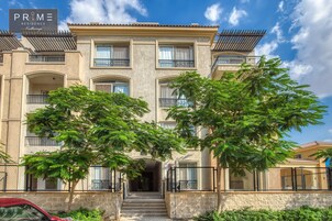 Um edifício residencial de vários andares com fachada de pedra, janelas amplas e sacadas.