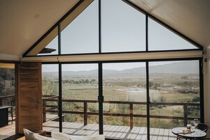 Quarto com uma janela grande que oferece vista para o campo.