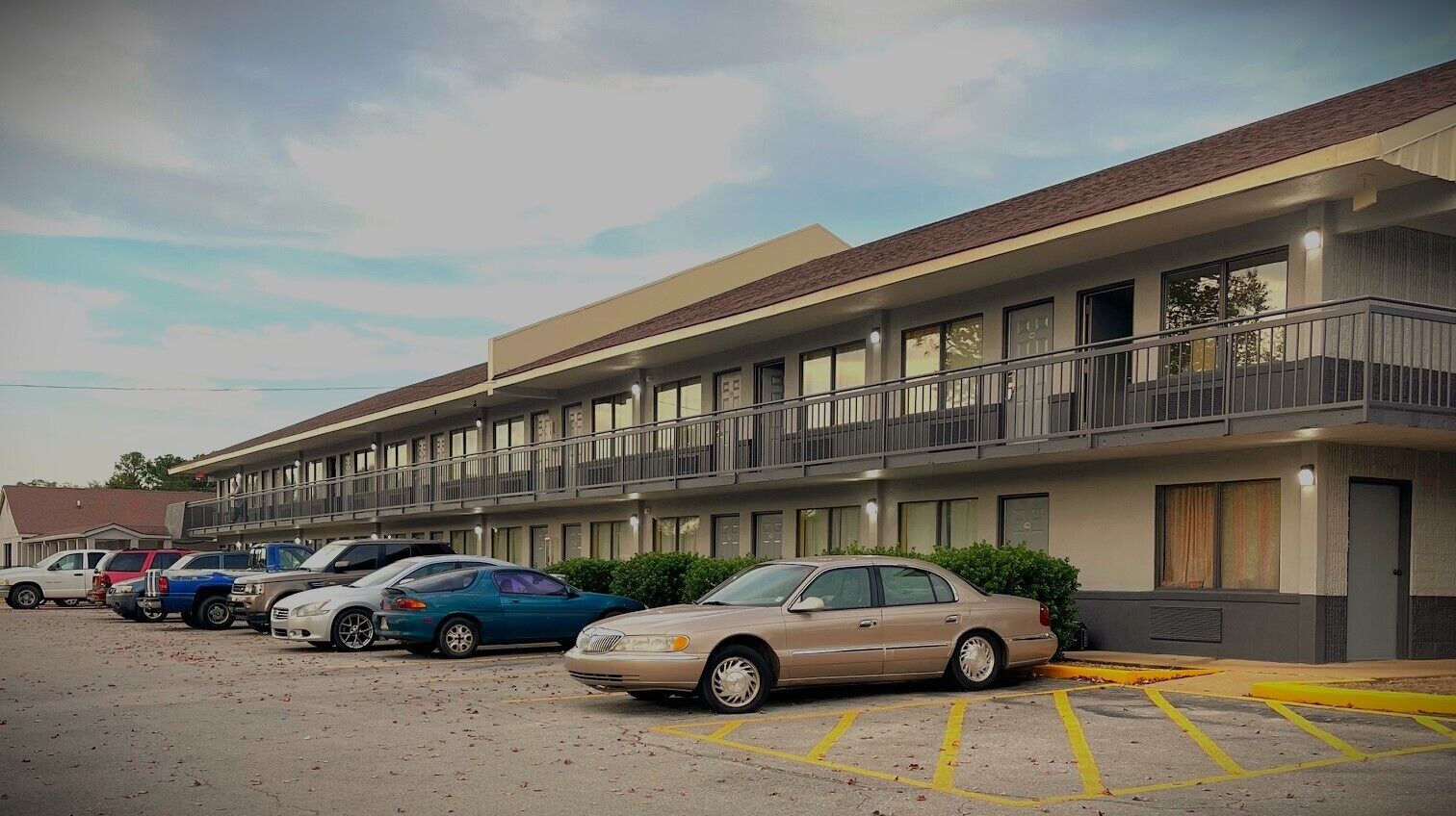 Um motel com vários andares e estacionamento.