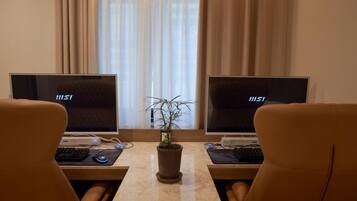 Um espaço de trabalho com dois monitores, teclado, rato e uma planta em vaso.