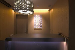 Interior moderno com parede de madeira, janela de vitrais e luminária de teto singular.