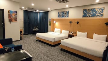 Quarto de hotel com duas camas, uma escrivaninha e uma cadeira.