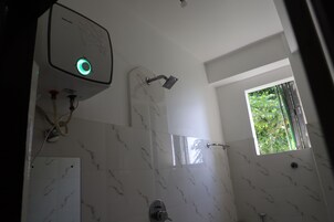 Casa de banho com chuveiro, janela e painel de controlo.