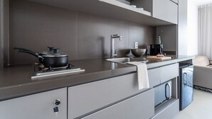 Cozinha moderna com fogão embutido, pia e lava-louças.