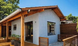 Uma casa moderna com deck de madeira, varanda coberta e o número 7 na parede.