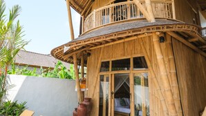 Estrutura de bambu com varanda e vista para o verde ao redor.