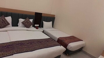 Cama de casal com cabeceira, duas almofadas e um manta decorativa.