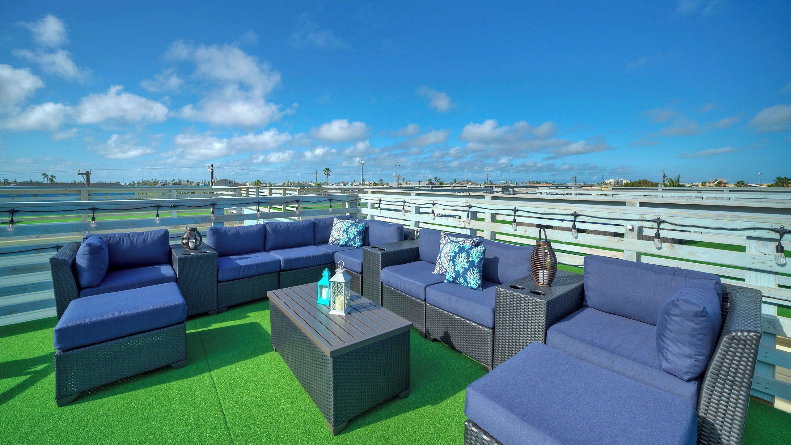 Um terraço com mobiliário externo, vista da cidade e guarda-corpo.