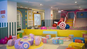 Espaço infantil com piscina de bolinhas, estruturas de escalada e brinquedos educativos.
