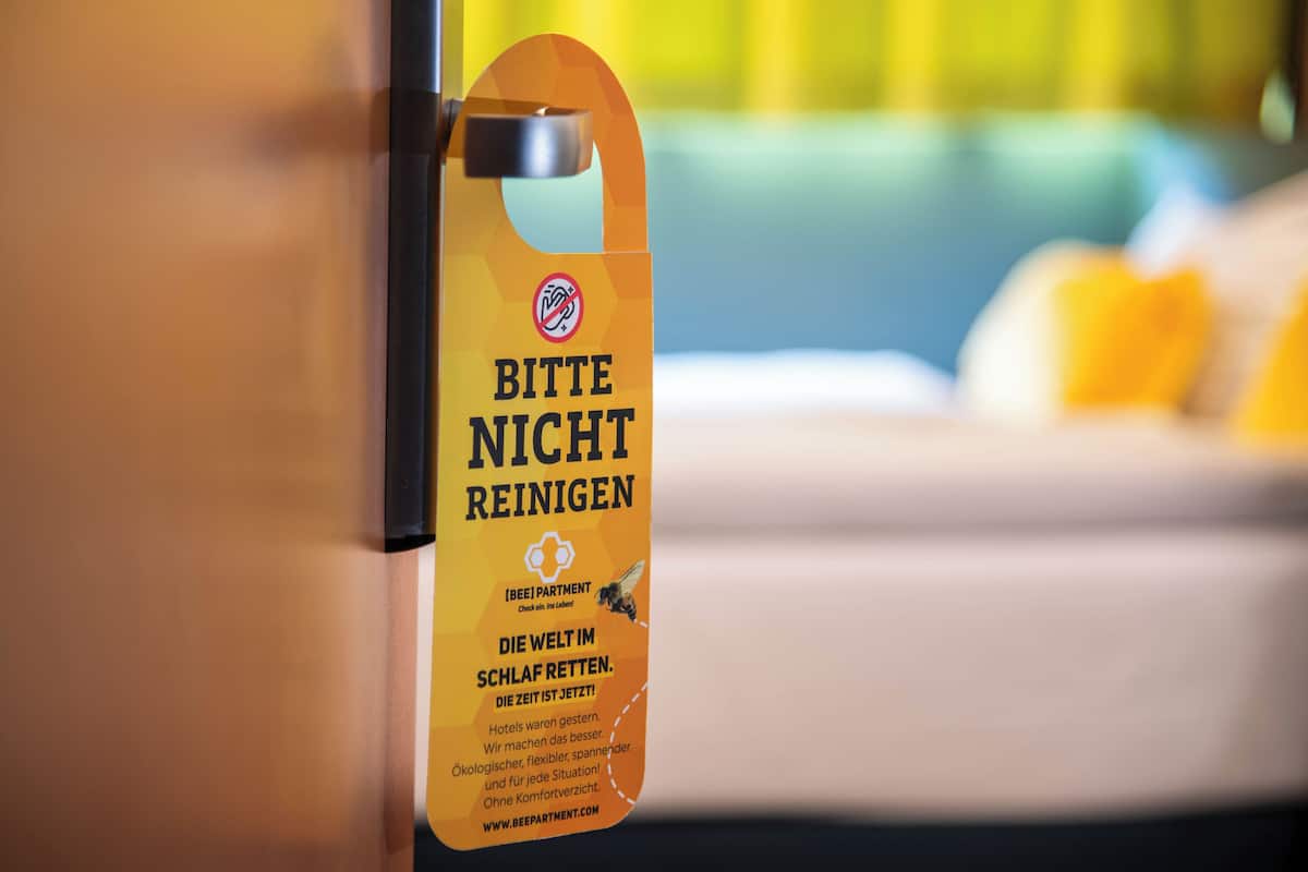 Uma placa com texto em alemão, provavelmente indicando uma regra ou diretriz do hotel.