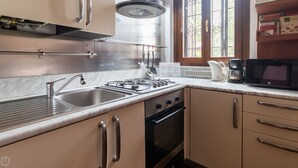 Uma cozinha moderna com eletrodomésticos de aço inoxidável, fogão a gás, pia e micro-ondas.