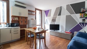Um espaço compacto para viver, com cozinha compacta, área de refeições e televisão.