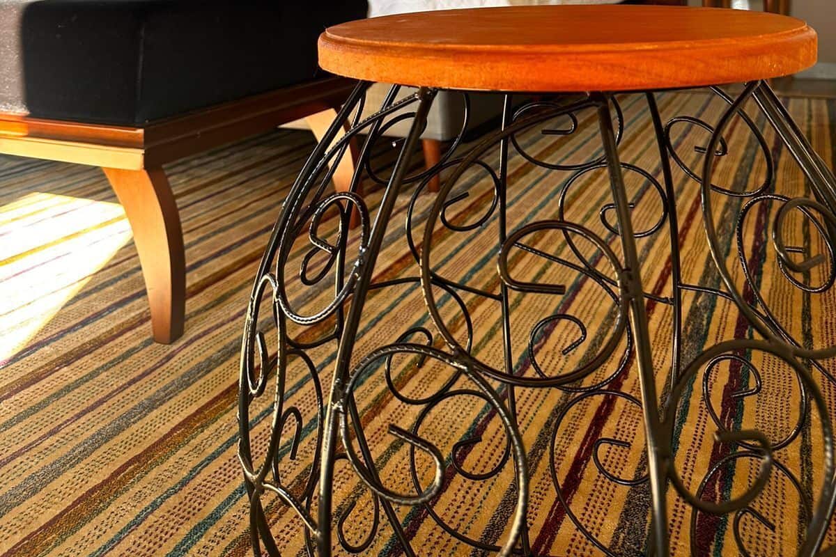 Quarto de hotel com cama, uma pequena mesa e ar condicionado.