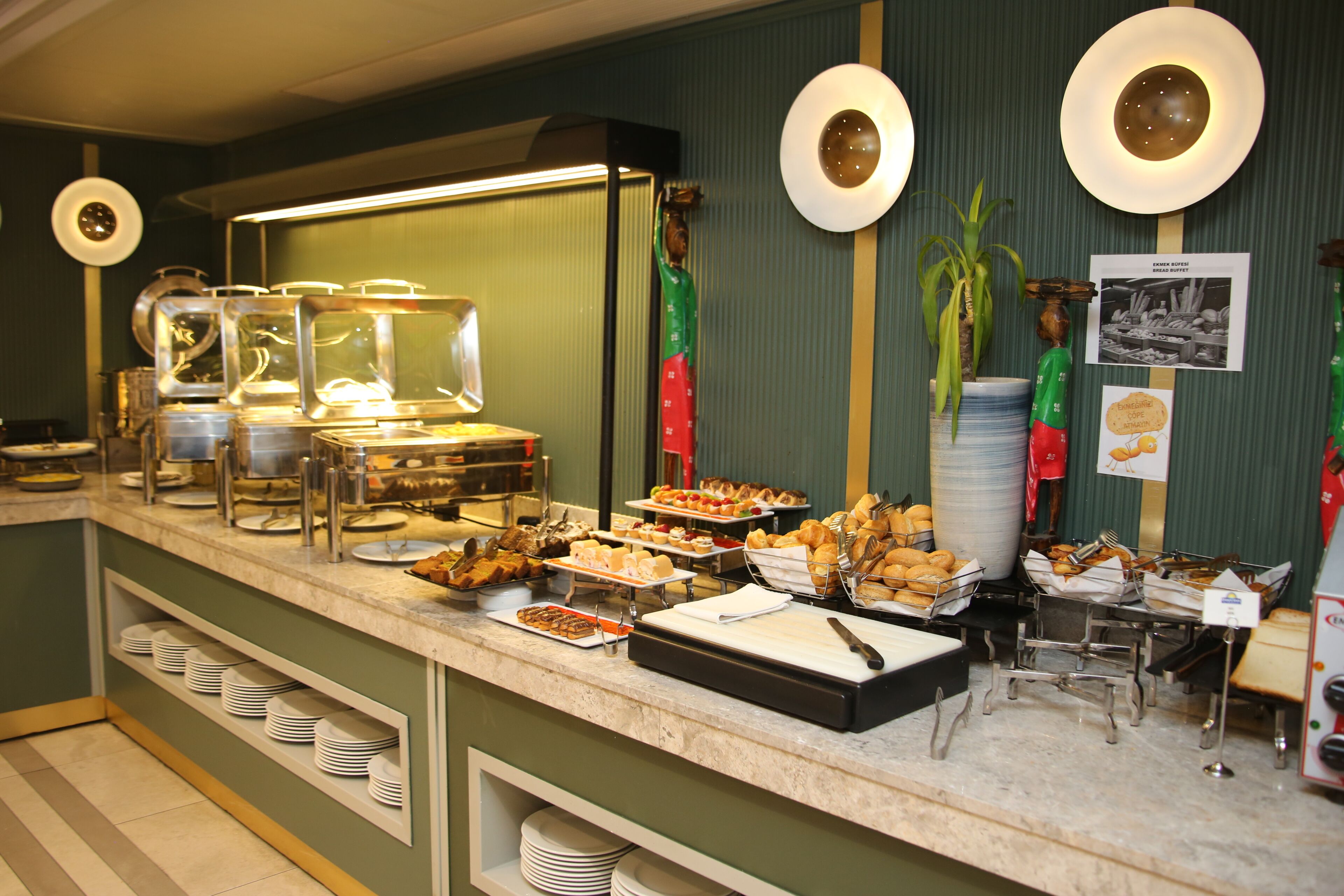 Disposição de buffet com diversos alimentos e utensílios de servir.