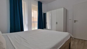 Quarto com cama, guarda-roupa e porta.