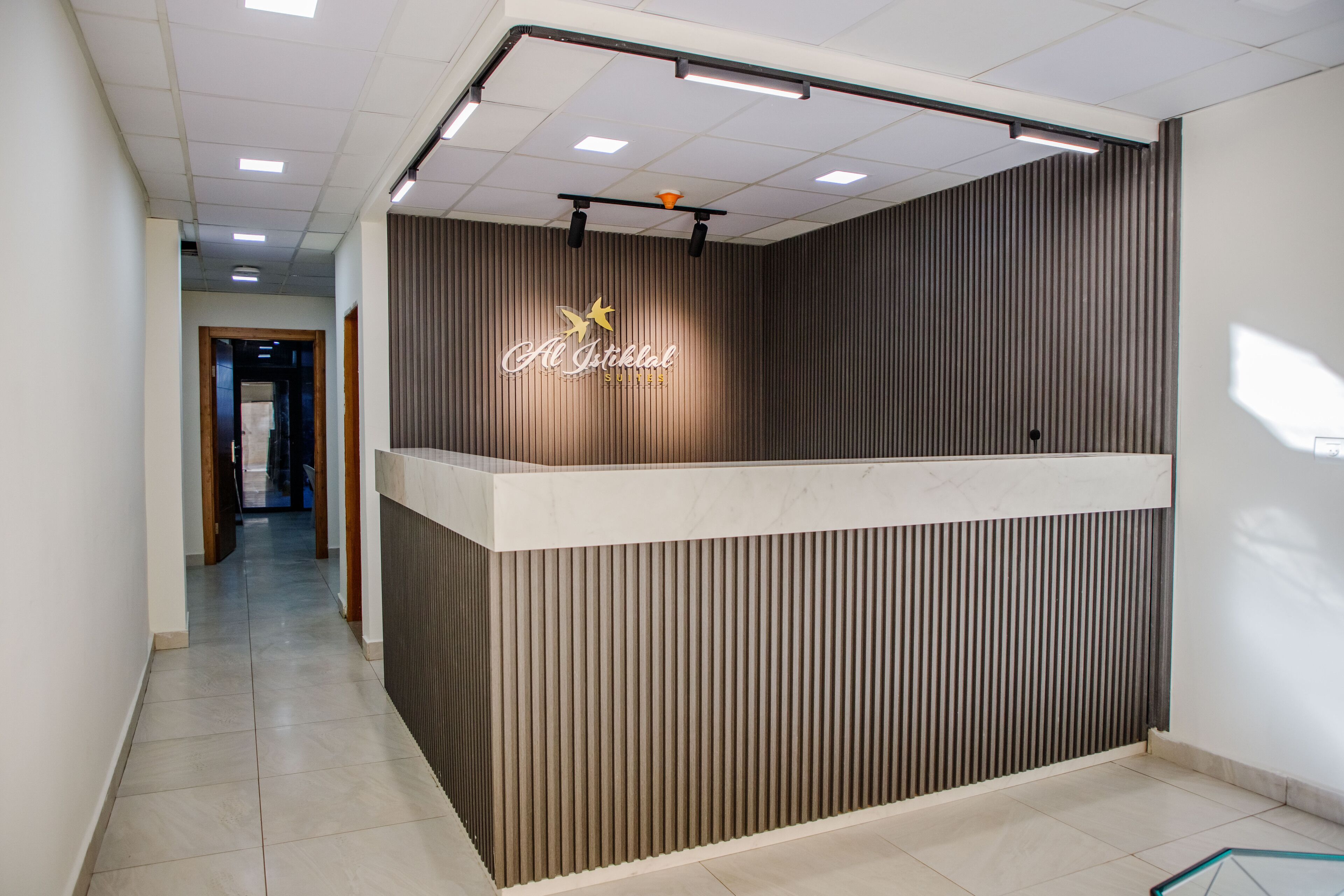 Balcão de recepção com design moderno, apresentando um logotipo e um painel vertical.