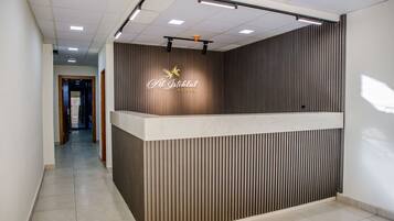 Balcão de recepção com design moderno, apresentando um logotipo e um painel vertical.