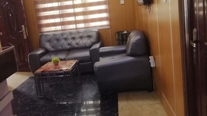 Uma sala de estar moderna com um sofá seccional, uma mesa de centro e uma lareira.