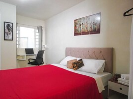 Quarto com cama, escrivaninha e cadeira.