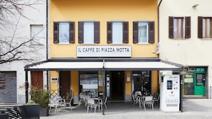 Um edifício amarelo com uma placa que diz "IL CAFFÈ DI PIAZZA MOTTA".