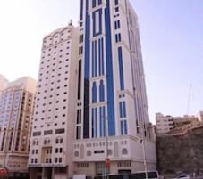 Um edifício alto e moderno com fachada branca e detalhes em azul.