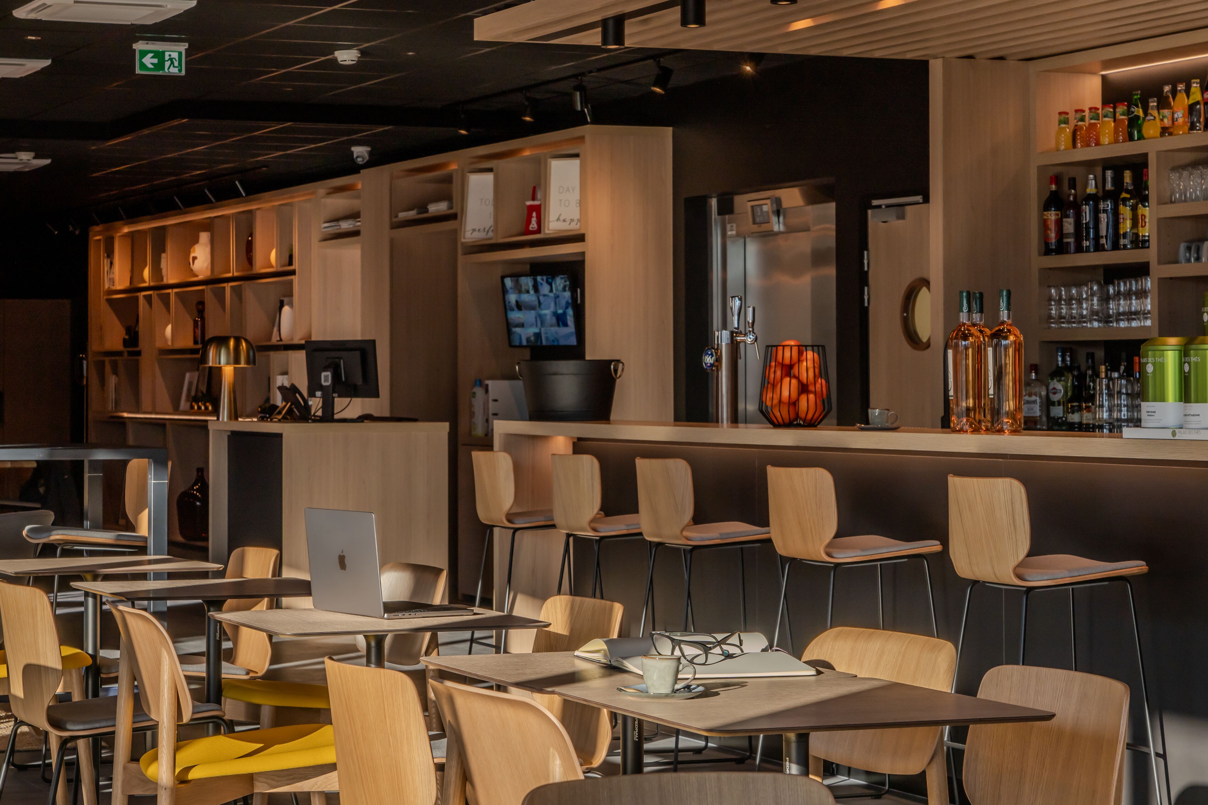 Uma área de bar moderna com assentos e uma televisão.