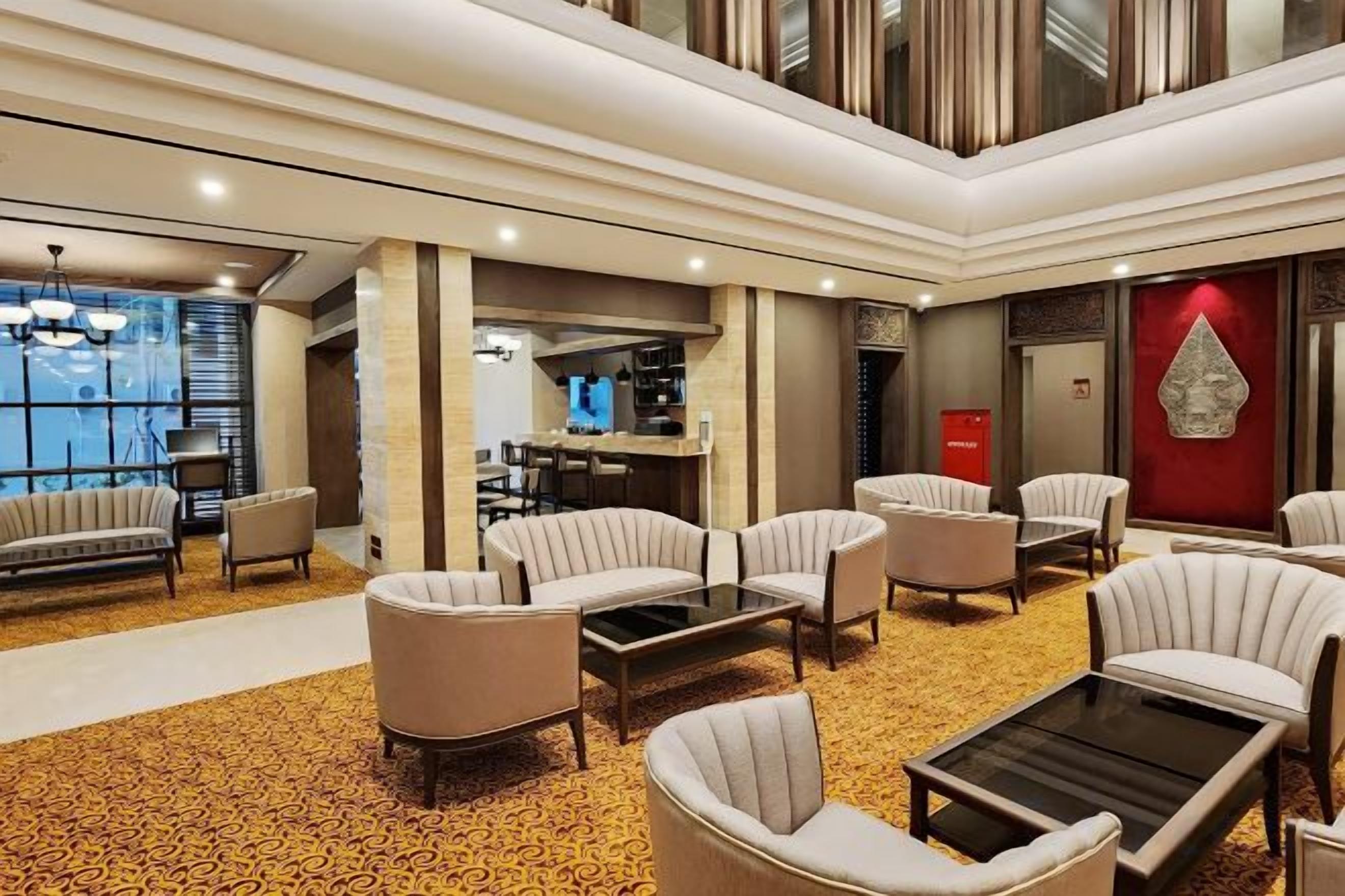 Um saguão de hotel com área de estar, bar e lareira.