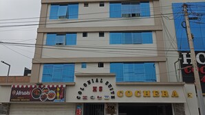 Um edifício de vários andares com uma placa indicando 'JACUZZI' e 'Colonial Suite', identificando-o como um hotel.
