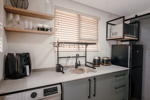 Uma cozinha moderna com máquina de lavar louça embutida, micro-ondas e máquina de café.