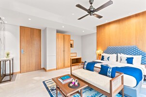 Quarto moderno com cama grande, guarda-roupa de madeira e ventoinha no teto.