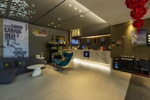 Um lobby moderno com balcão de atendimento, área de estar e uma parede com um mapa.