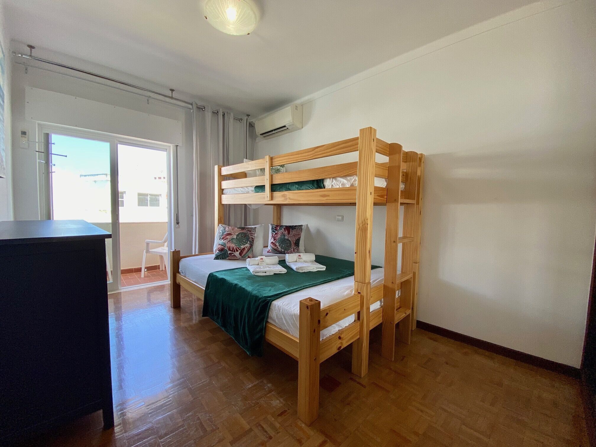 Quarto com cama de solteiro, escrivaninha e cadeira.