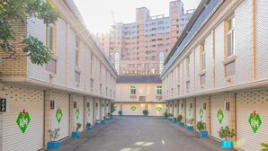 Um pátio com área central aberta, rodeado por edifícios com portões de garagem numerados.