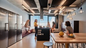 Cozinha moderna com eletrodomésticos de aço inoxidável, uma ilha central e um letreiro de neon.