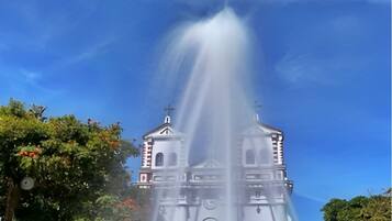 Uma igreja com uma fonte central e um céu azul límpido.