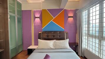 Quarto de hotel com cama, guarda-roupa, mesa de cabeceira e janela com vista para a cidade.
