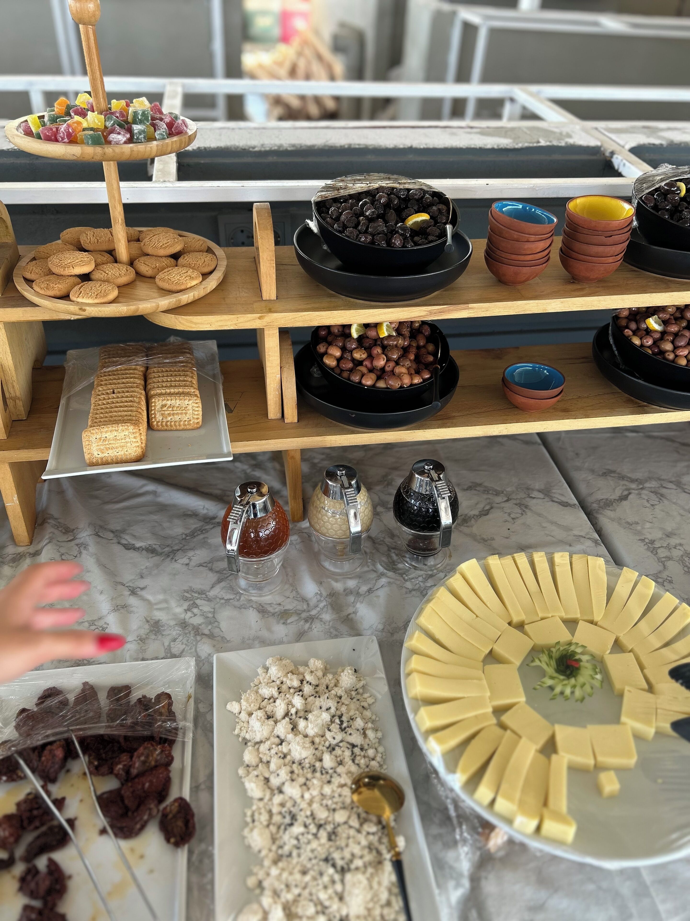 Uma mesa de buffet com diversos alimentos, incluindo biscoitos, nozes e queijo.