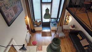 Escada que leva a um segundo andar, com vista para uma área de refeições abaixo.