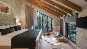 Quarto com uma cama grande, uma cadeira, uma janela e uma televisão.