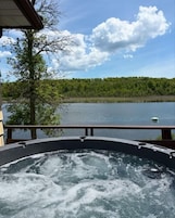 Uma banheira de hidromassagem com vista para um lago e floresta.