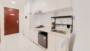 Uma cozinha moderna com armários brancos, lava-louças embutida e uma pia de aço inoxidável.