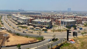 Paisagem urbana com edifícios modernos, uma estrada sinuosa e um canteiro de obras.