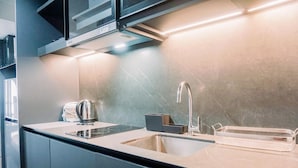 Uma cozinha moderna com fogão embutido, pia e eletrodomésticos de aço inoxidável.