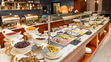 Buffet com diversos alimentos e um espaço de serviço por autoatendimento.